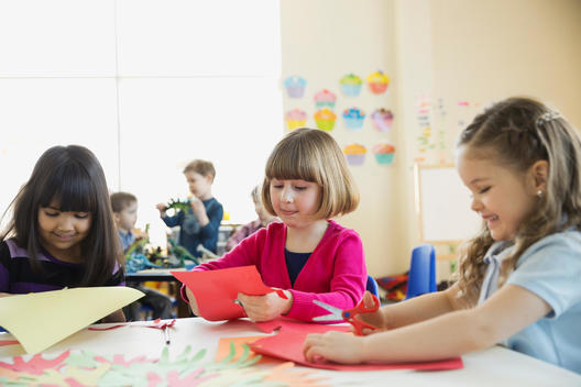 Smiling girls making crafts in elementary class - Stock Image - Everypixel