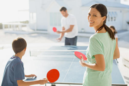 Family playing table tennis together outdoors - Stock Image - Everypixel
