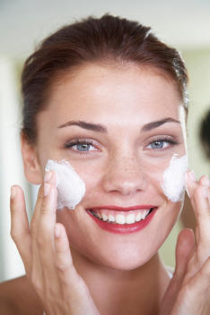 Young woman applying face cream - Stock Image - Everypixel