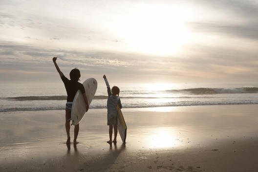 Mother and daughter say goodbye to sun after surfing. - Stock Image ...